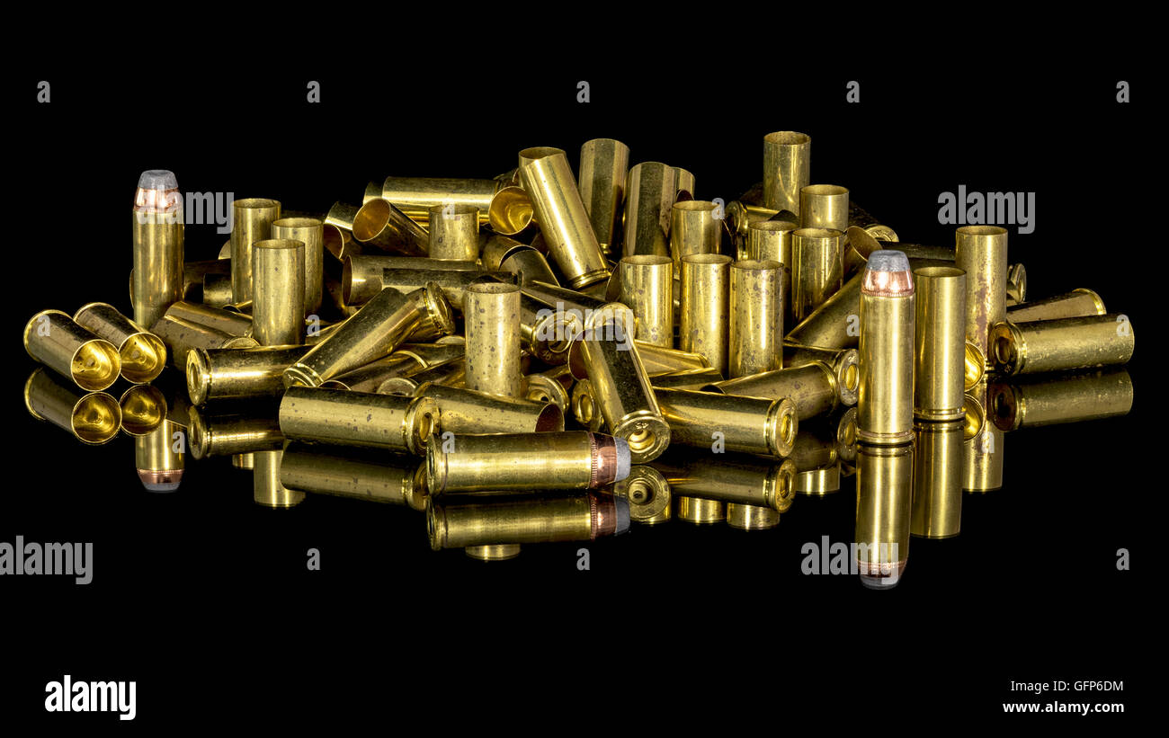 Empty Pistol brass and loaded bullets on a reflective surface Stock ...