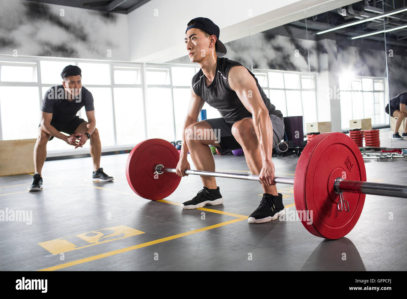 Young Chinese man working with trainer at gym Stock Photo - Alamy
