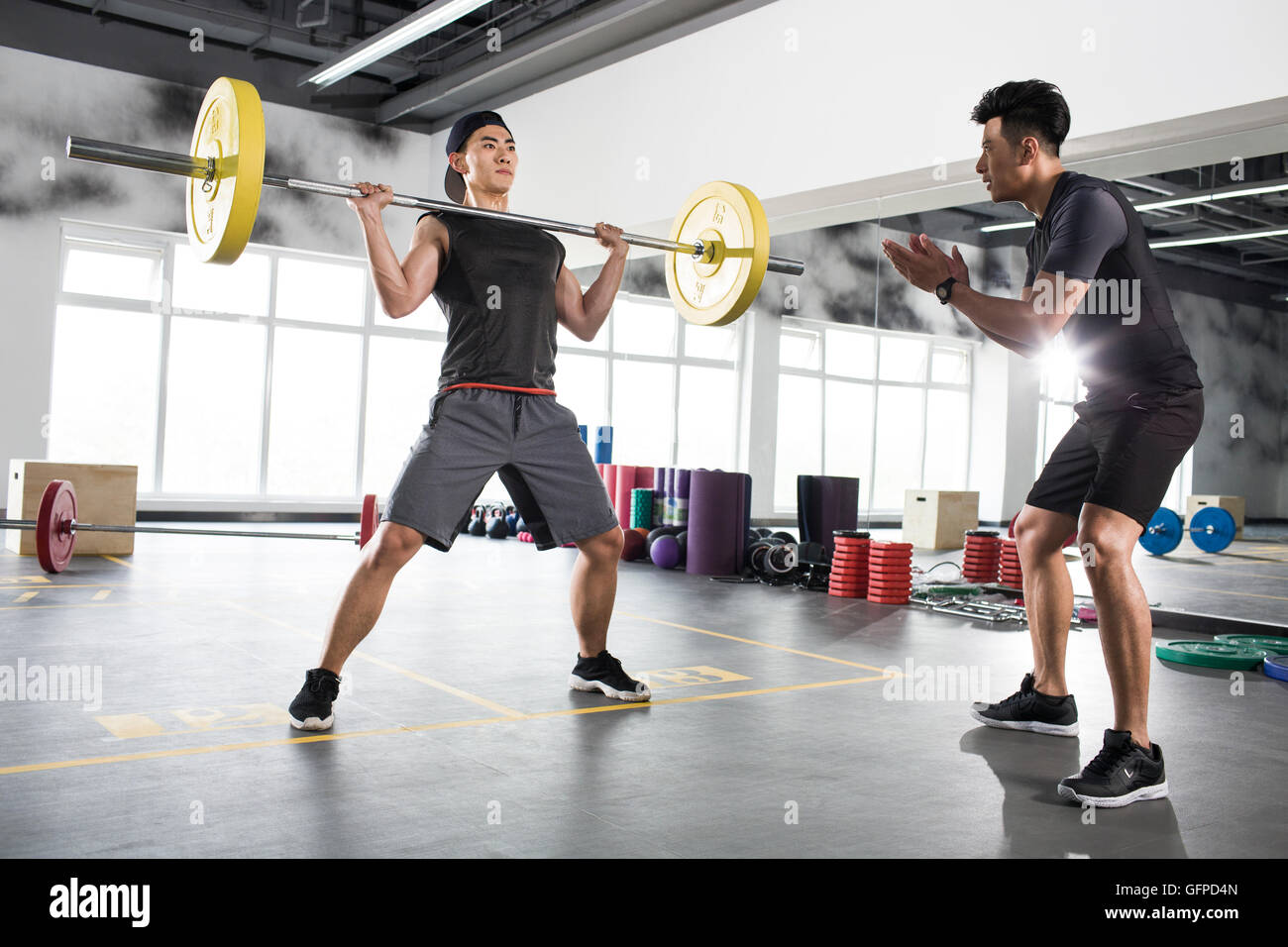 Young Chinese man working with trainer at gym Stock Photo - Alamy