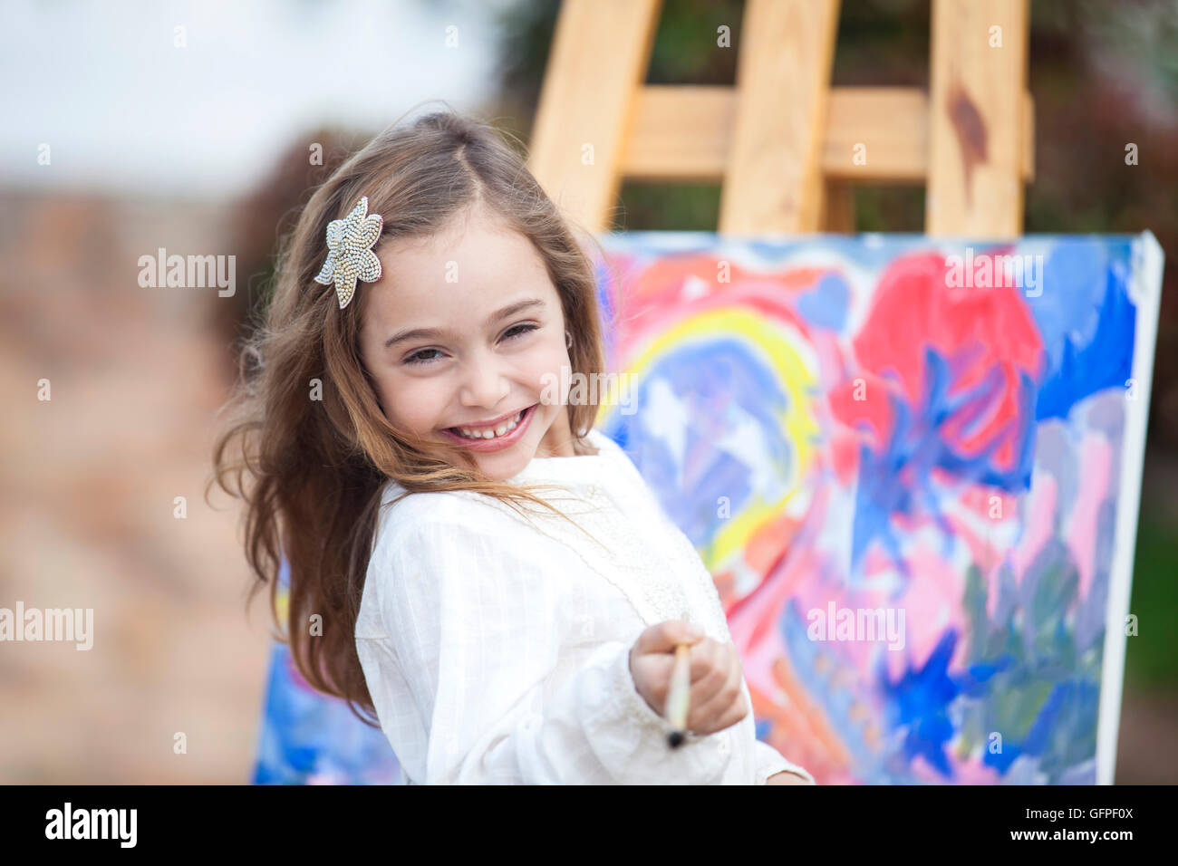 Little artist creating a painting and having a great time outdoors ...