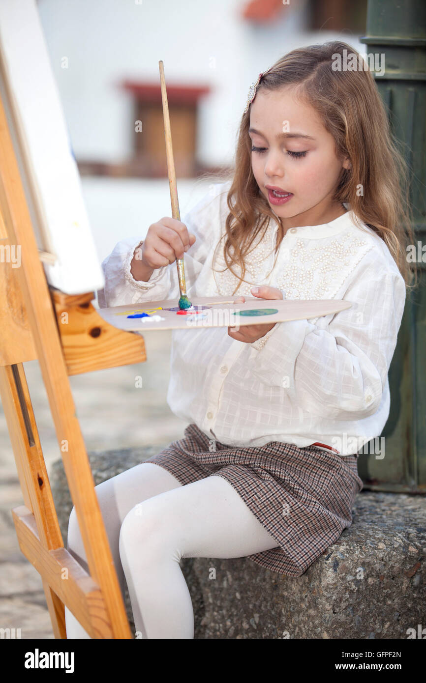 Little artist creating a painting and having a great time outdoors ...