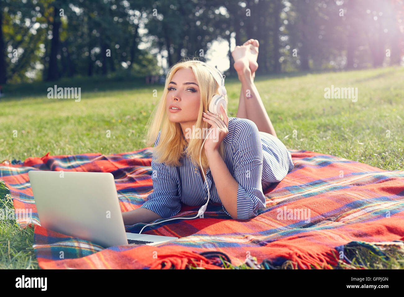 Girl lying on the green grass and listening to music Stock Photo - Alamy