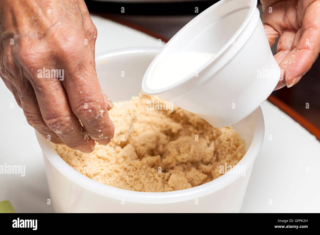 Adding milk to dough Stock Photo - Alamy