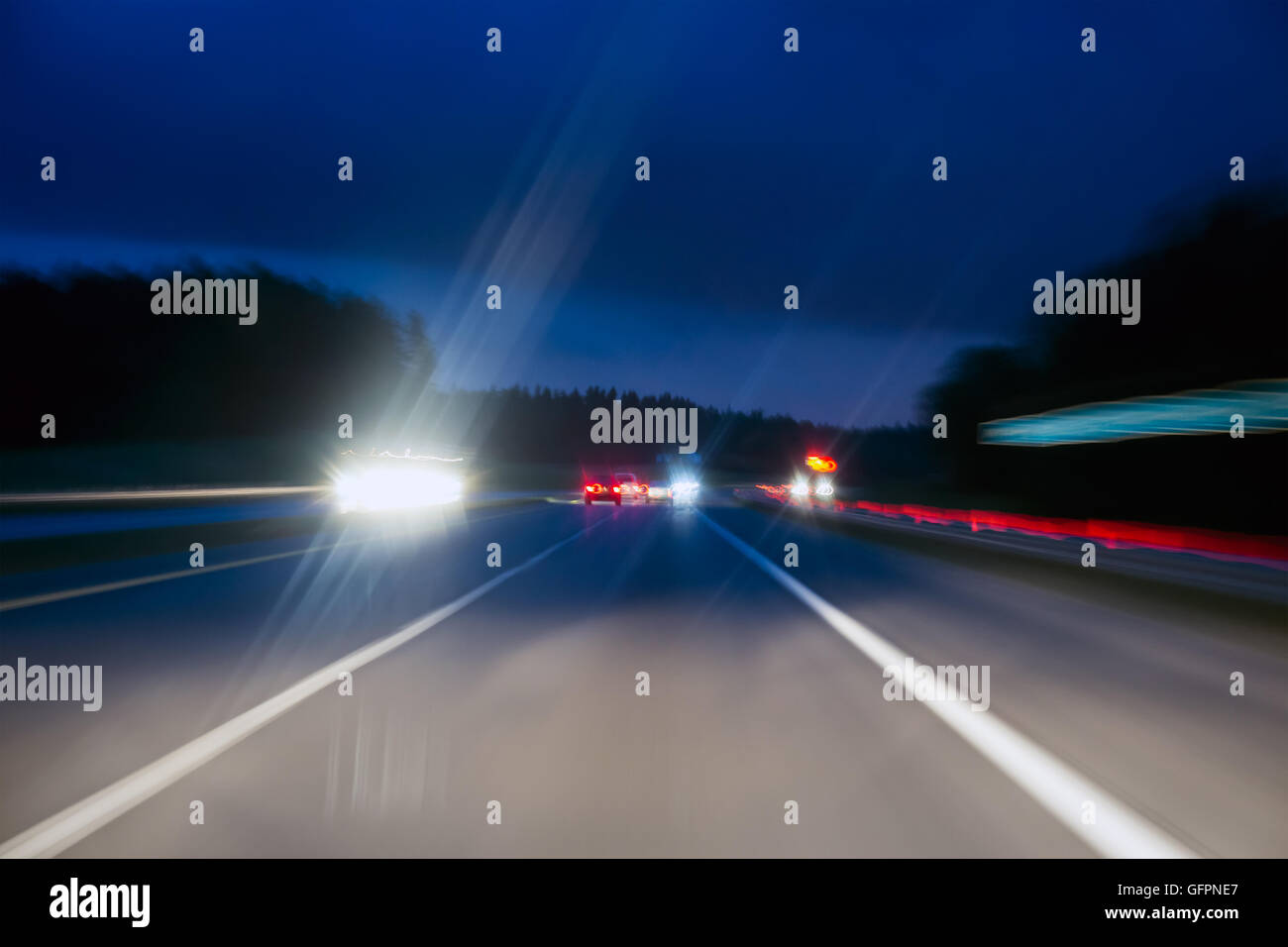Cars driving in dark oncoming hi-res stock photography and images - Alamy