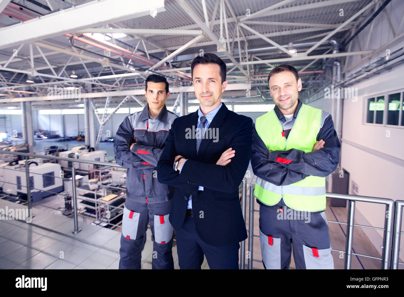 Team of manager and two workers in CNC factory Stock Photo - Alamy