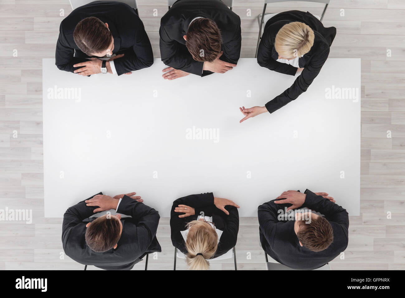 Business team sitting around white table, white copy space Stock Photo ...