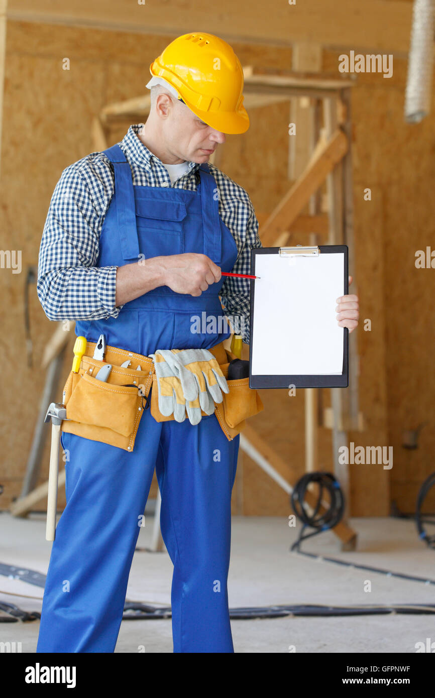 Portrait of foreman pointing at white folder plate Stock Photo - Alamy