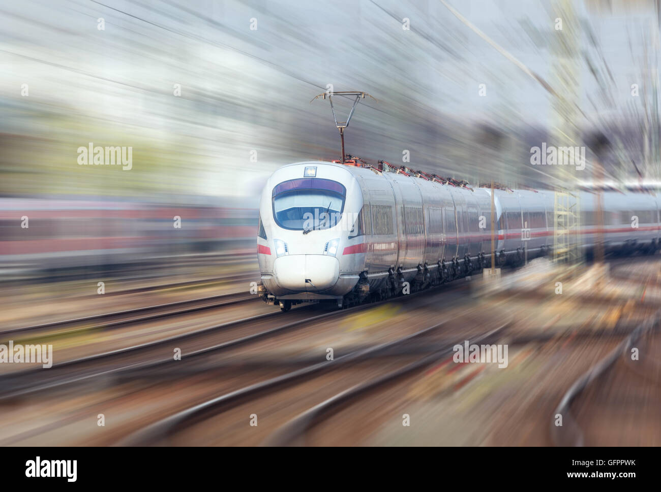 Railway station with modern high speed train in motion in the evening ...