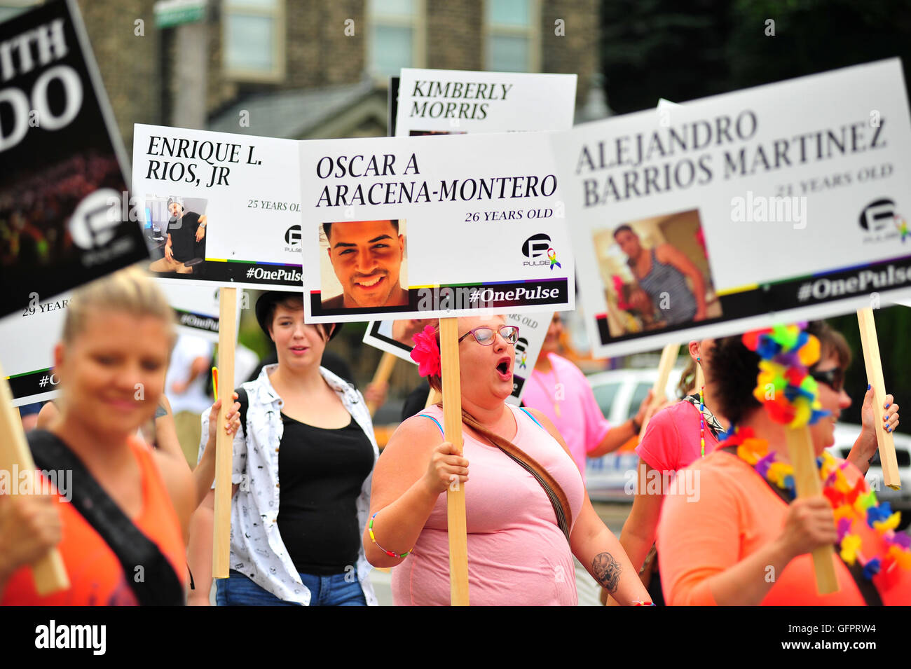 People hold up signs in remembrance of the victims of the Pulse ...