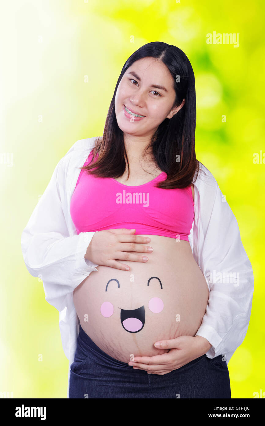 Happy pregnant woman with smiley face on her belly Stock Photo - Alamy