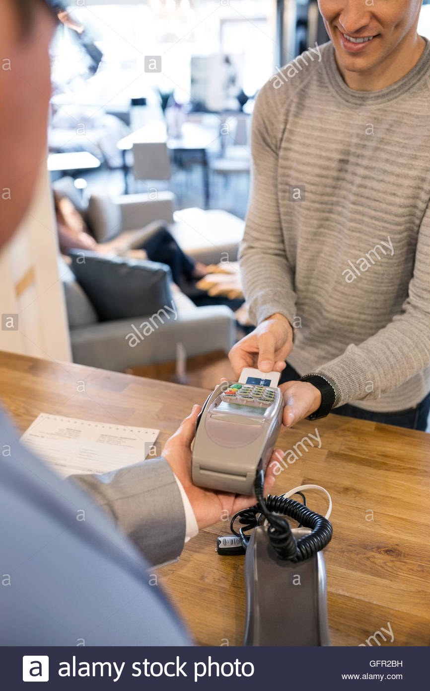Man paying using credit card reader in home furnishings store Stock ...