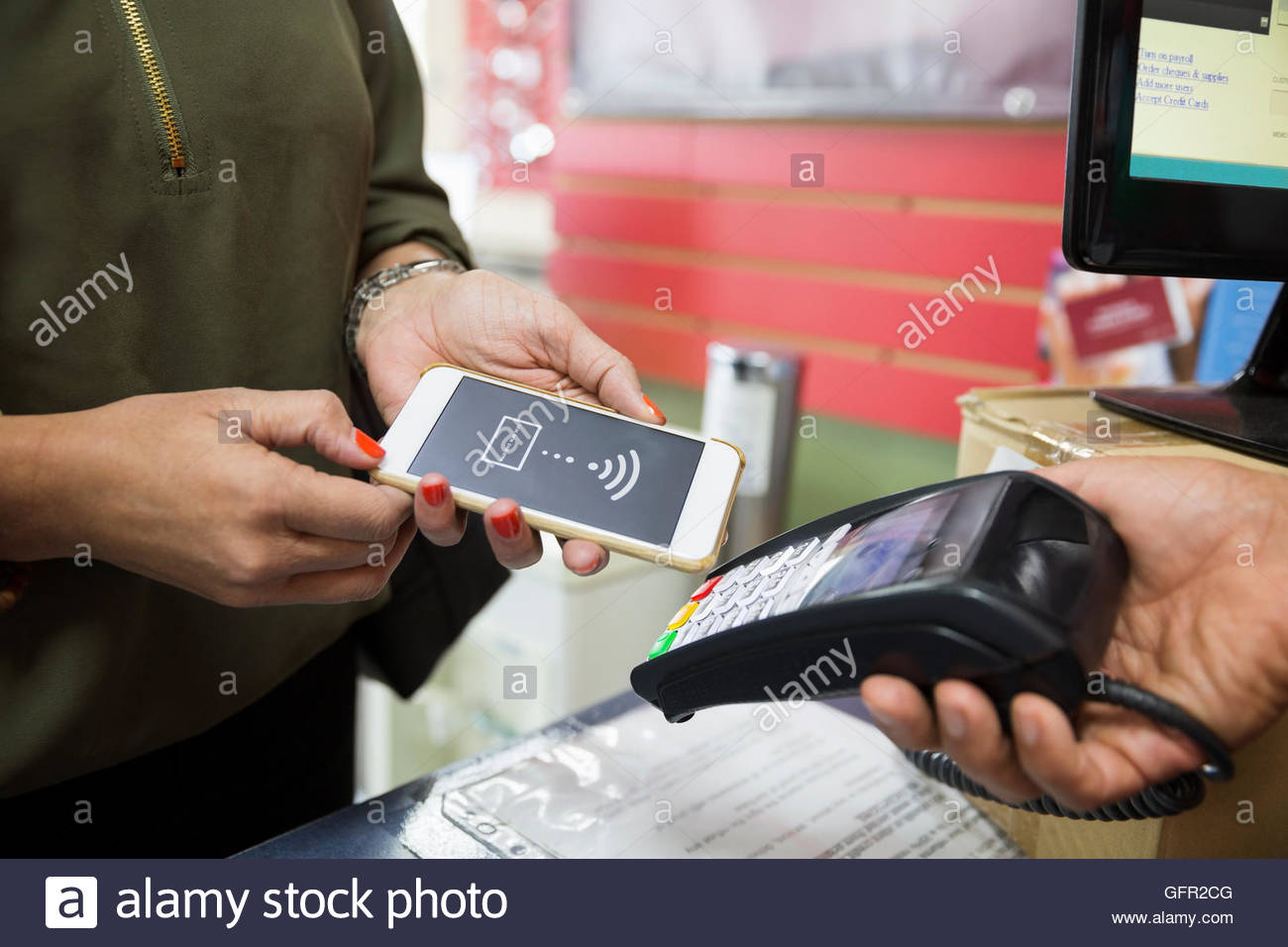 Close up woman paying using smart phone contactless payment in store ...