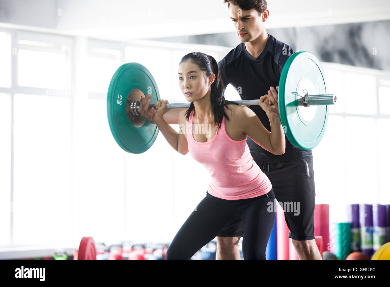 Young Chinese woman working with trainer at gym Stock Photo - Alamy