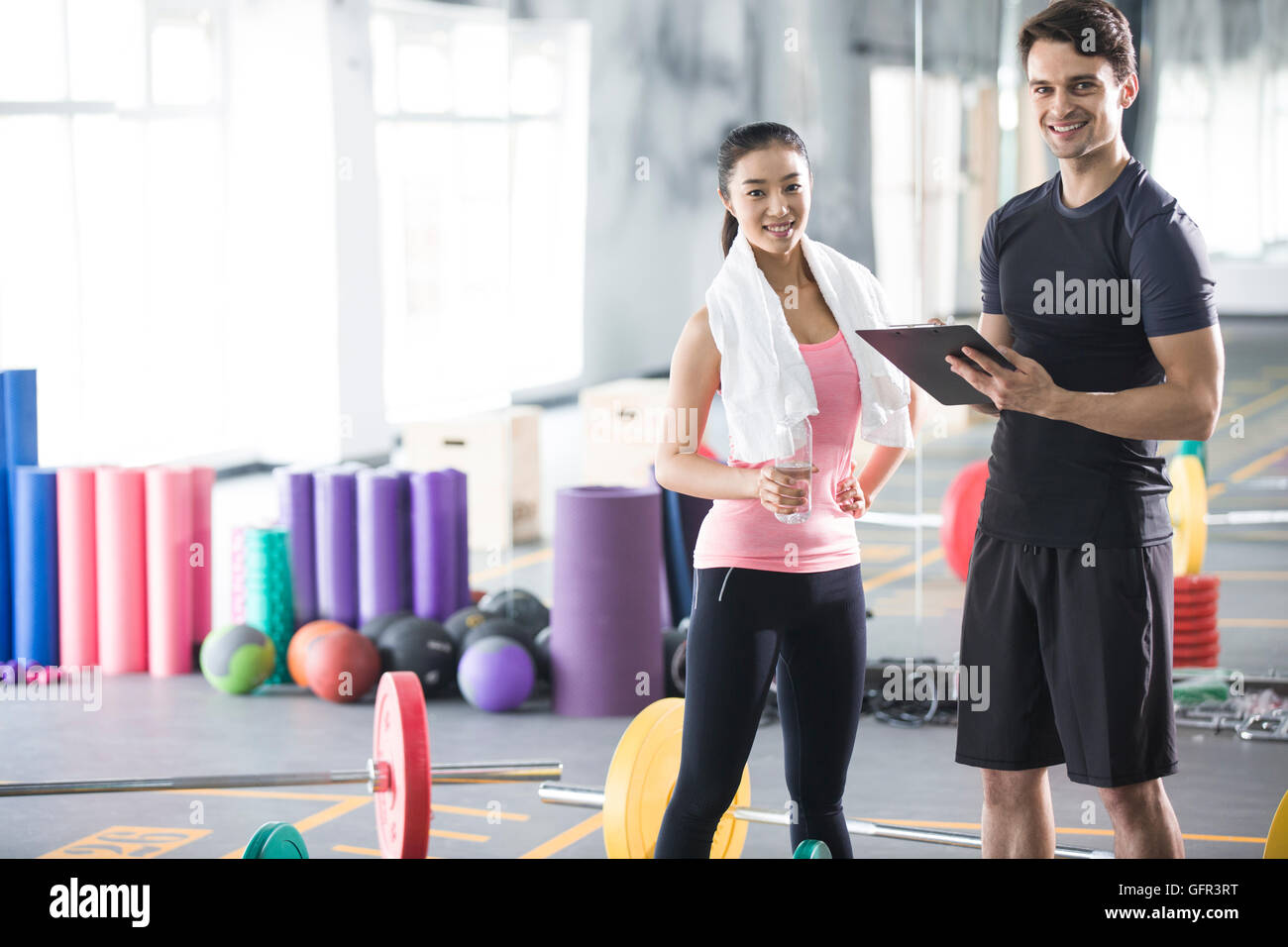 Young Chinese woman working with trainer at gym Stock Photo - Alamy