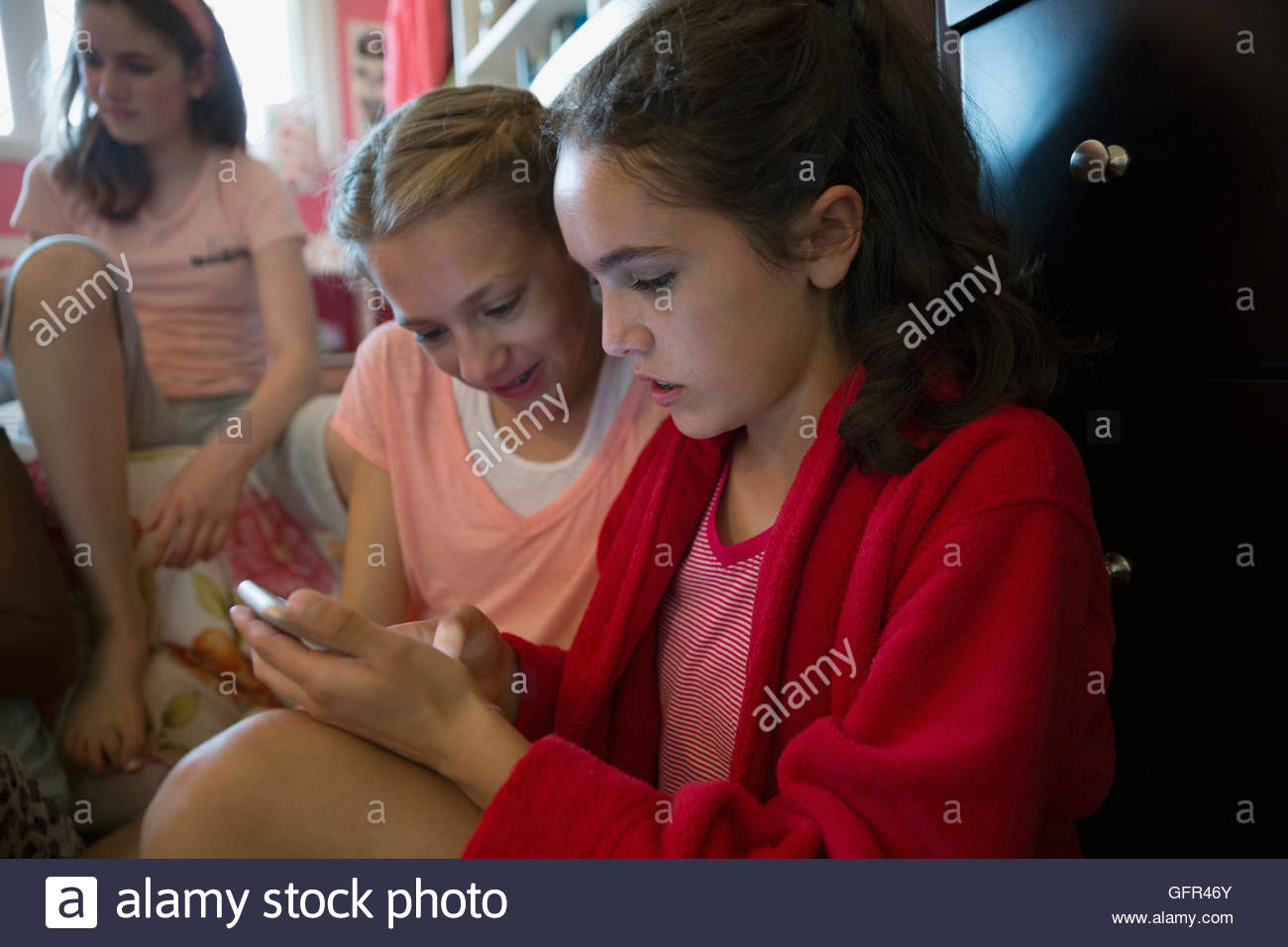 Girls using cell phone at slumber party Stock Photo - Alamy