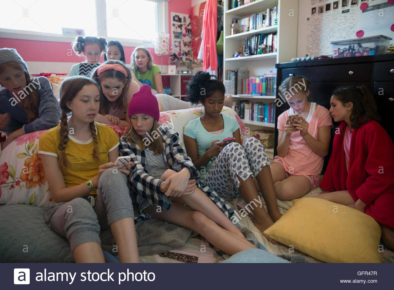Girls using cell phones at slumber party in bedroom Stock Photo - Alamy