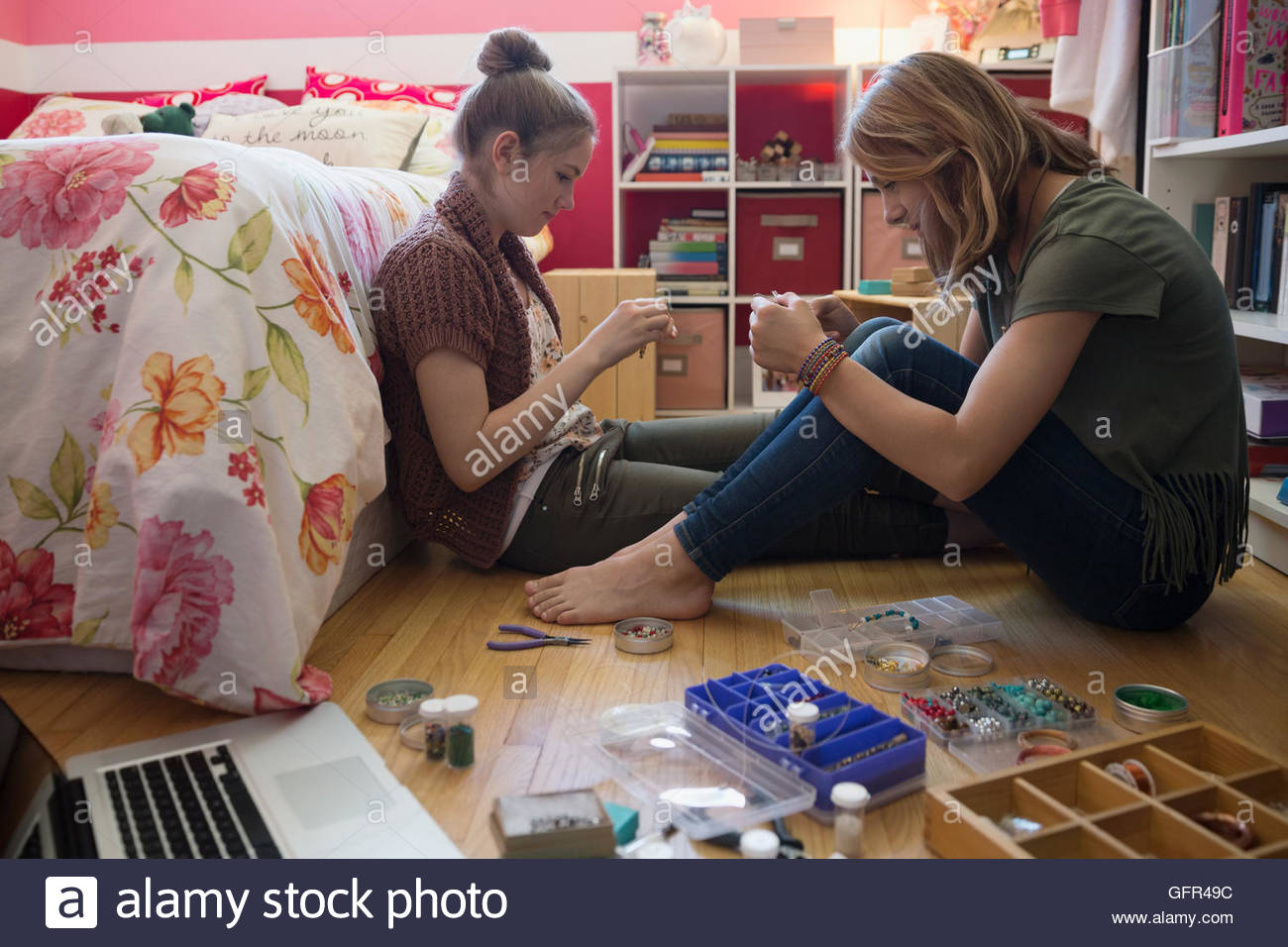 Girls making jewelry on bedroom floor Stock Photo - Alamy