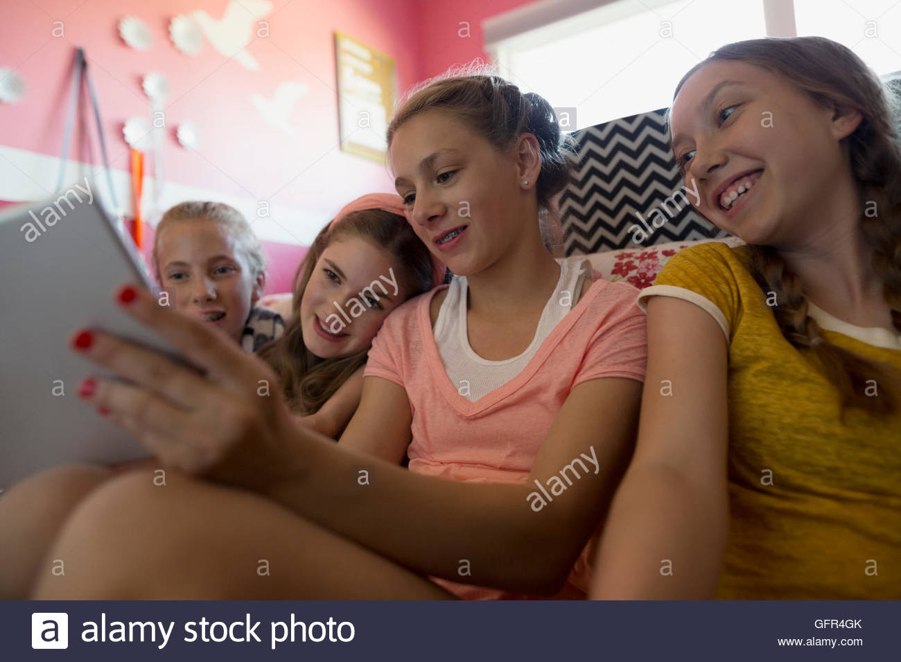 Girls using digital tablet at slumber party Stock Photo - Alamy