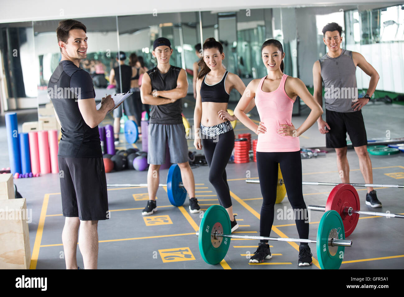 Young Chinese adult working with trainer at gym Stock Photo - Alamy