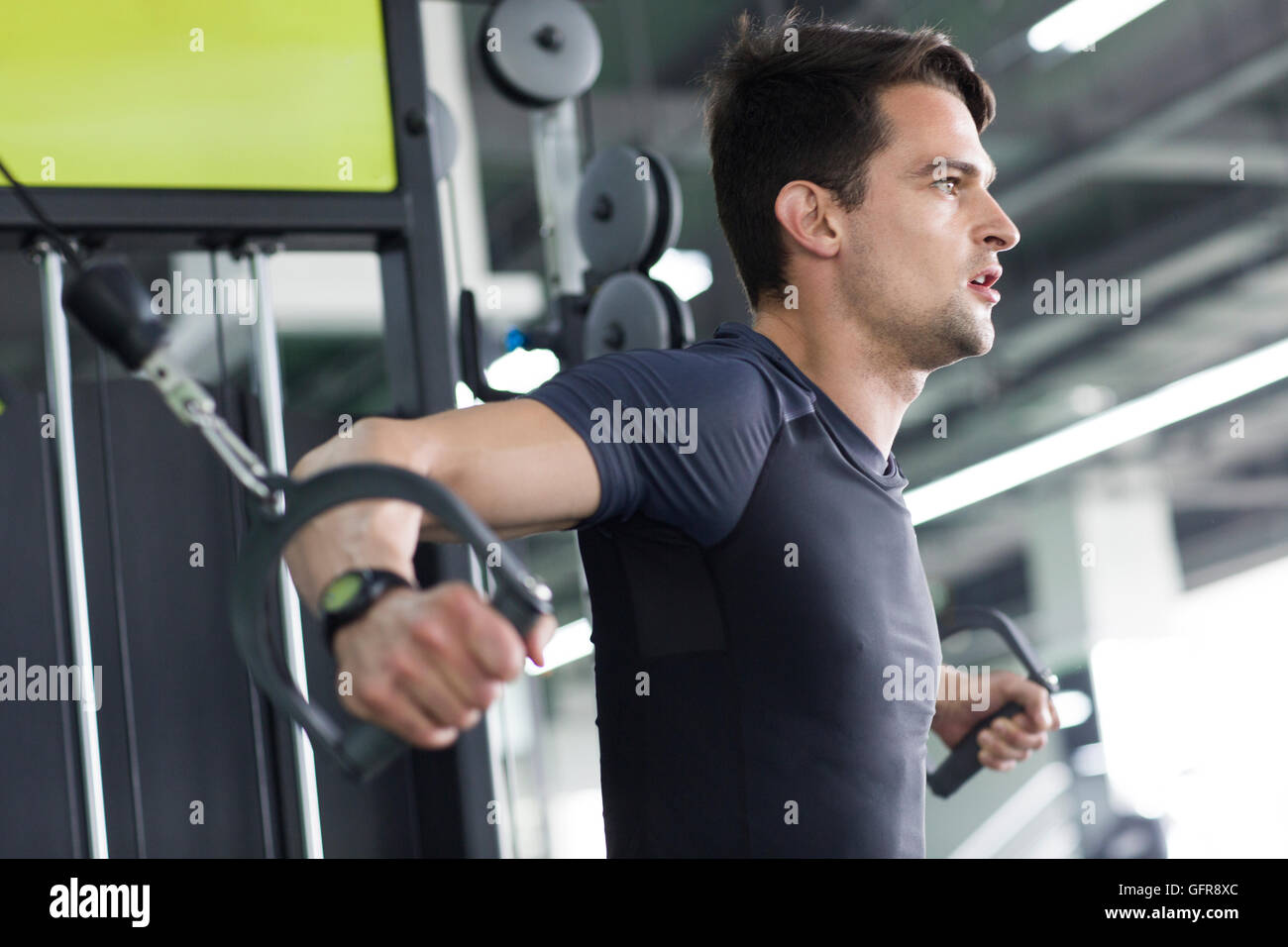 Young man exercising at gym Stock Photo - Alamy