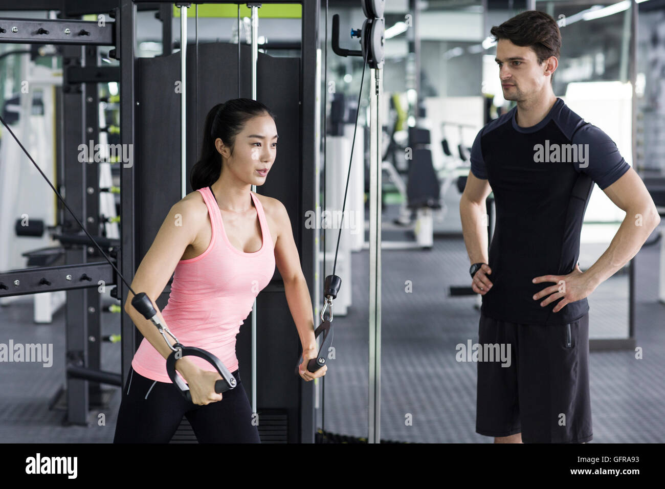 Young Chinese woman working with trainer at gym Stock Photo - Alamy