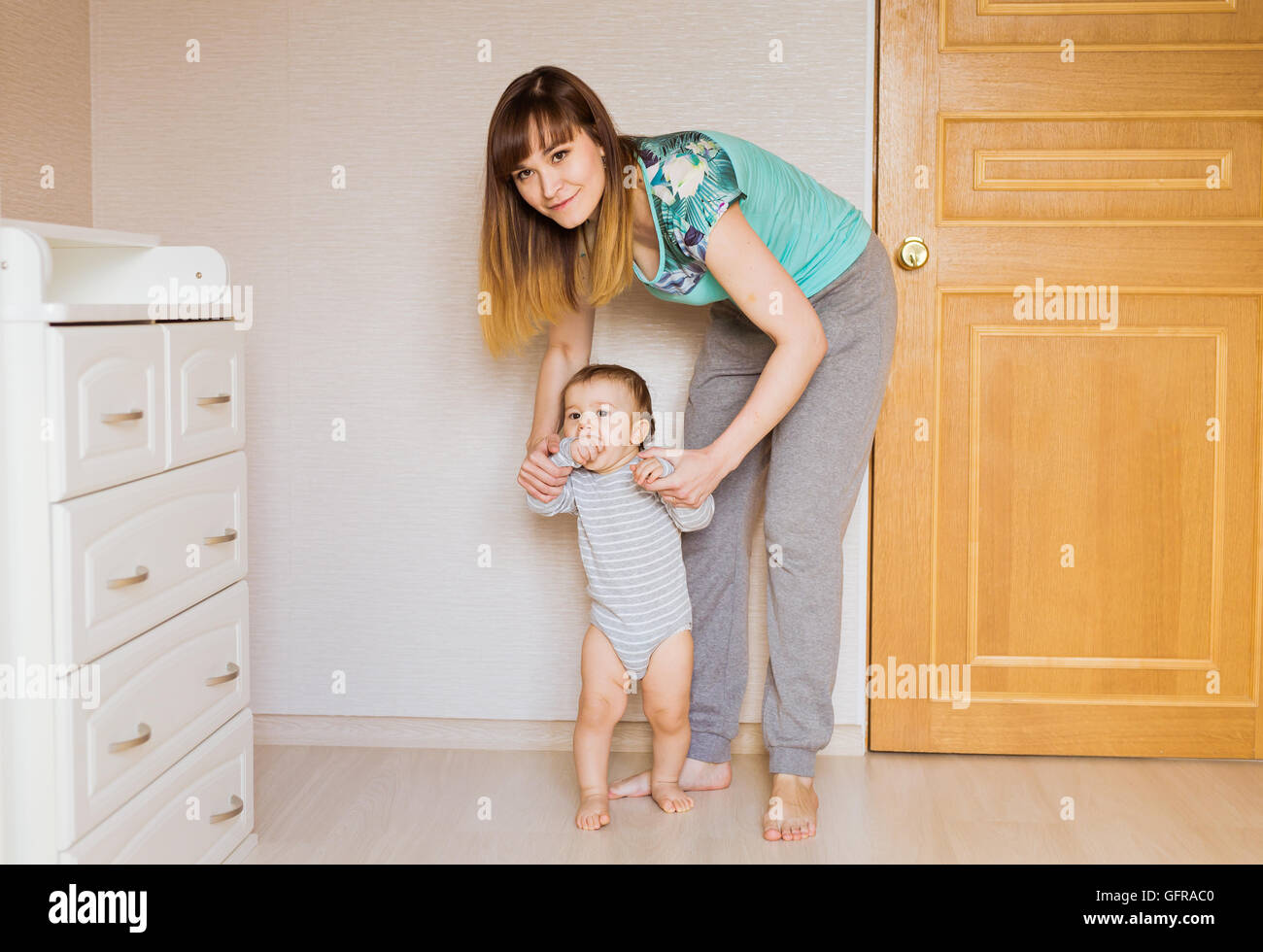 little boy first steps with the help of mother Stock Photo - Alamy