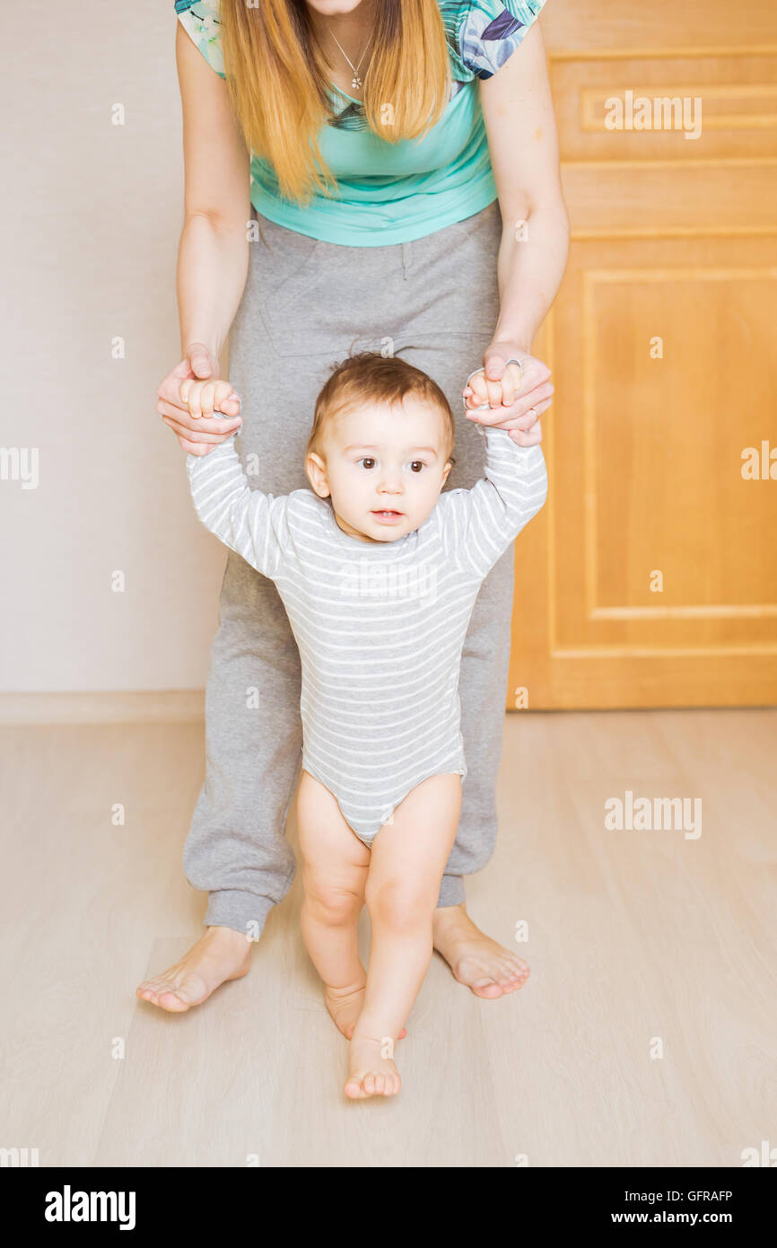 little boy first steps with the help of mother Stock Photo - Alamy