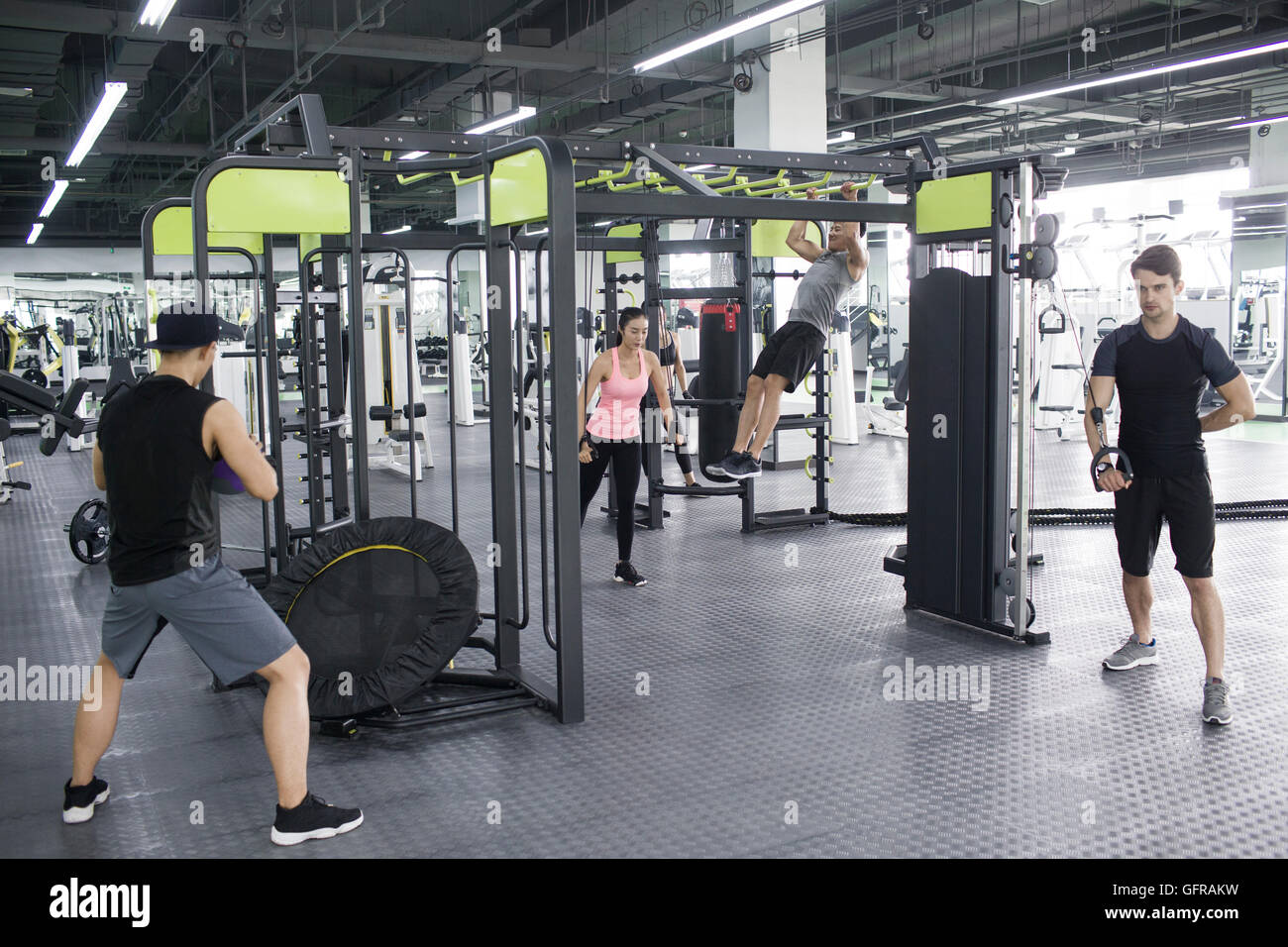Young adult using exercise machine at gym Stock Photo - Alamy