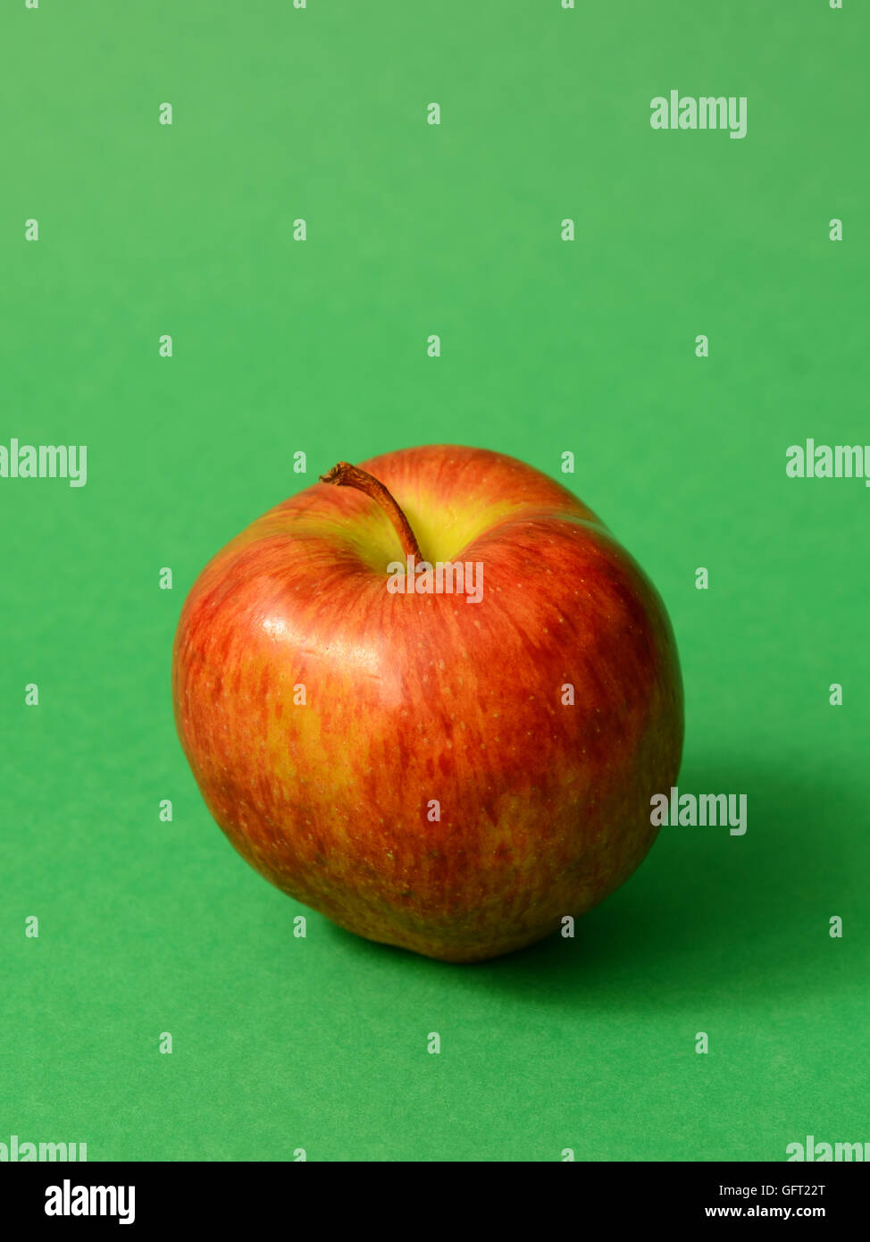 Fresh red apple on a green background Stock Photo - Alamy