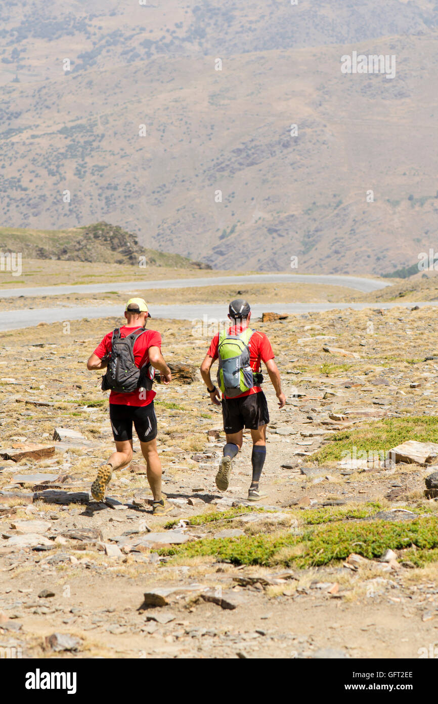Two Trail runners following path in barren landscape of Sierra Nevada ...