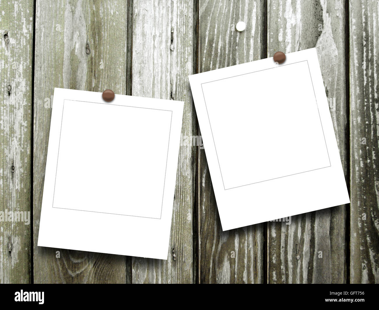 Close-up of two blank instant photo frames with pins on wooden boards ...