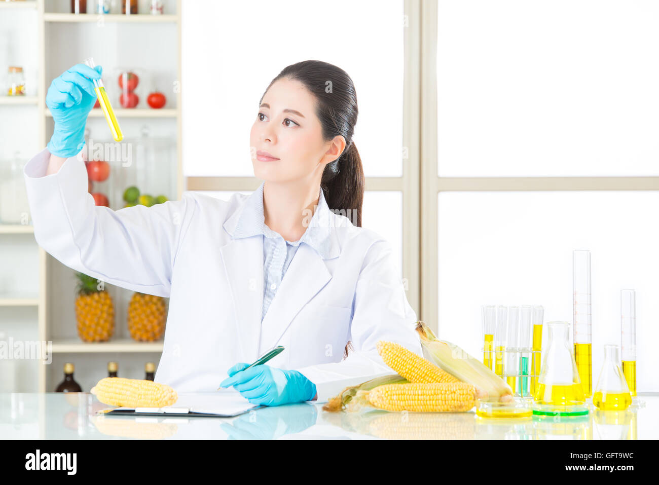 Asian female scientist thinking and holding an corn for genetic ...