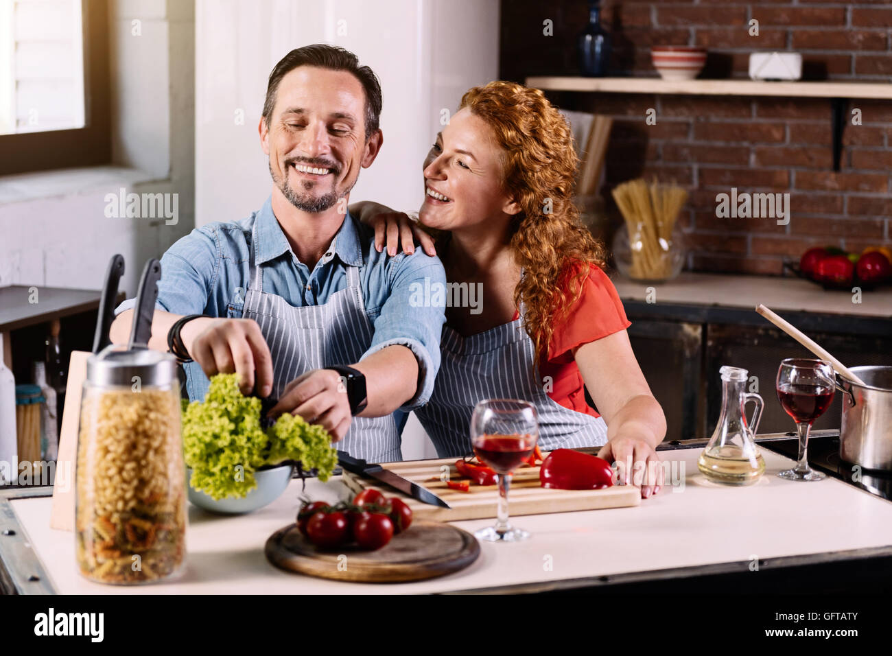 Couple sitting and cooking at table Stock Photo - Alamy