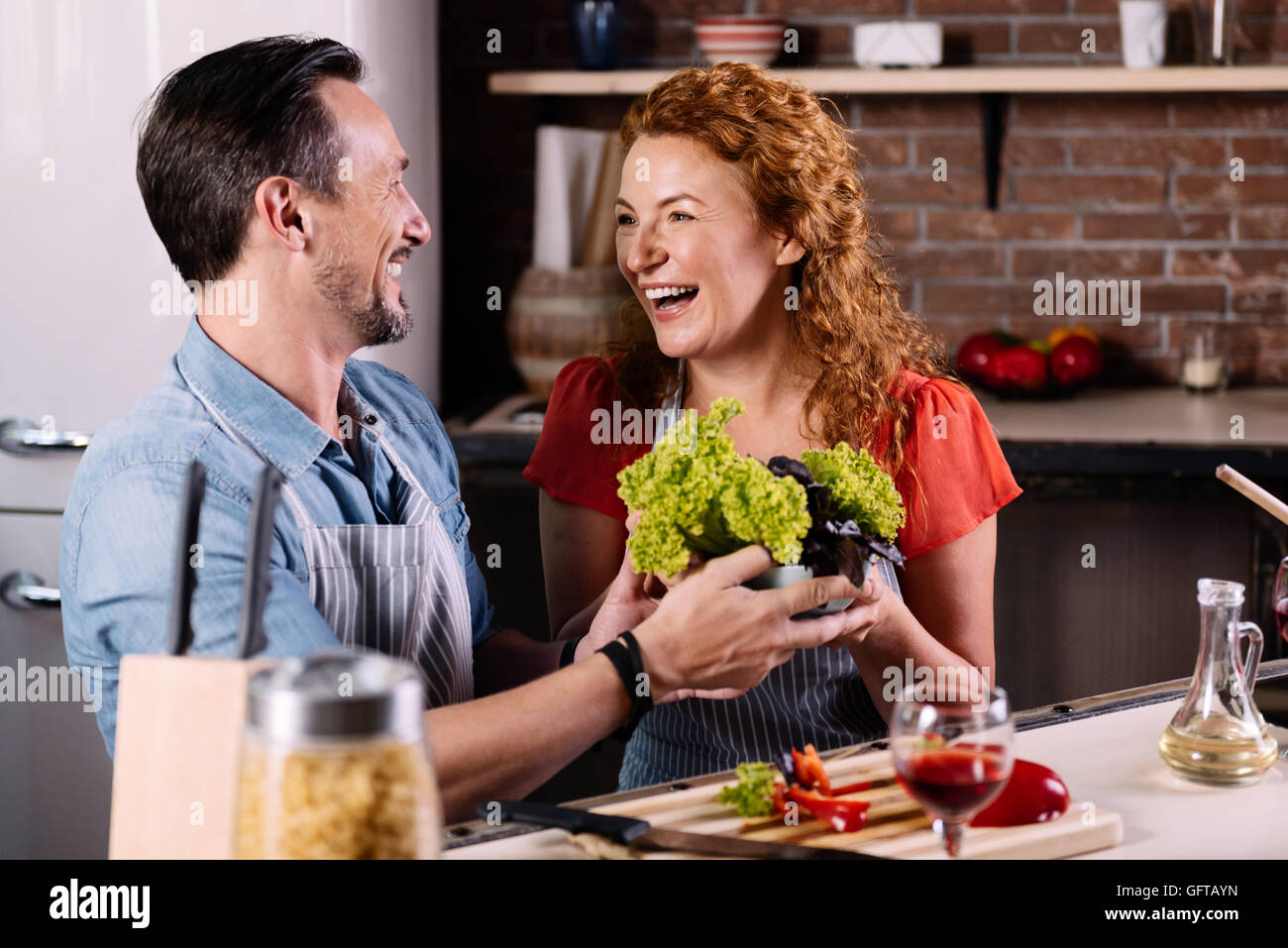 Couple laughing and cooking vegetables Stock Photo - Alamy