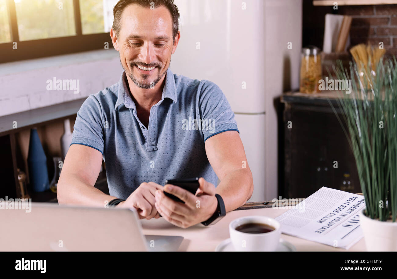 Smiling man looking at his phone Stock Photo - Alamy