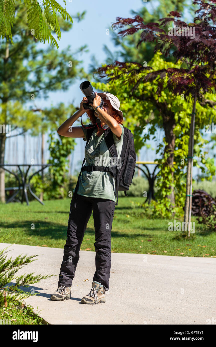 Professional nature photographer lady with her camera in the field ...