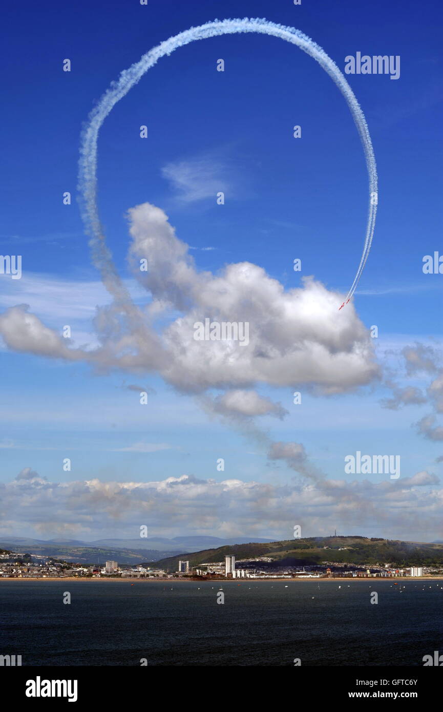 red arrows display team above the sea with a 360 white smoke against a ...