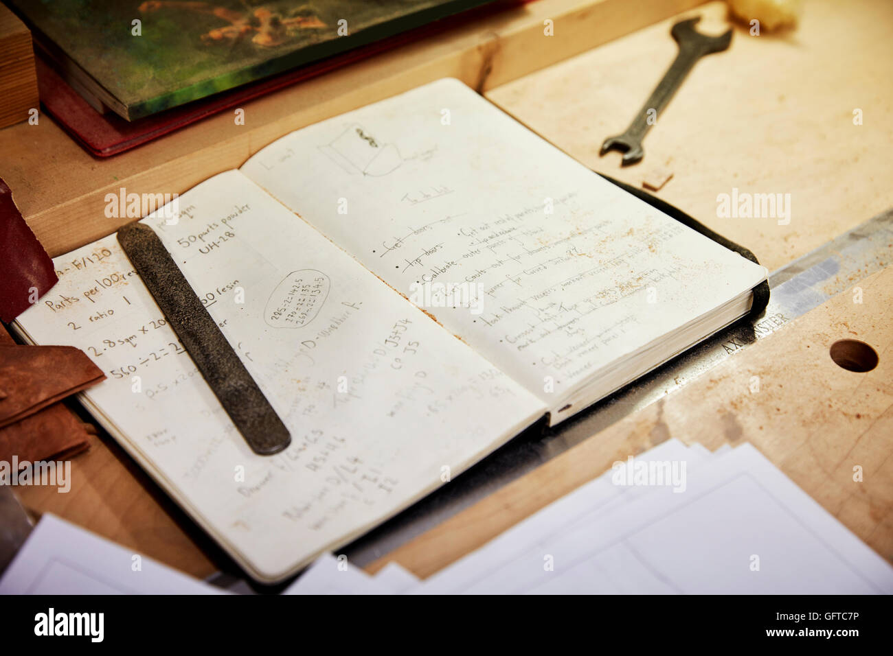 A furniture workshop Hand written notes in a notebook on a workbench ...