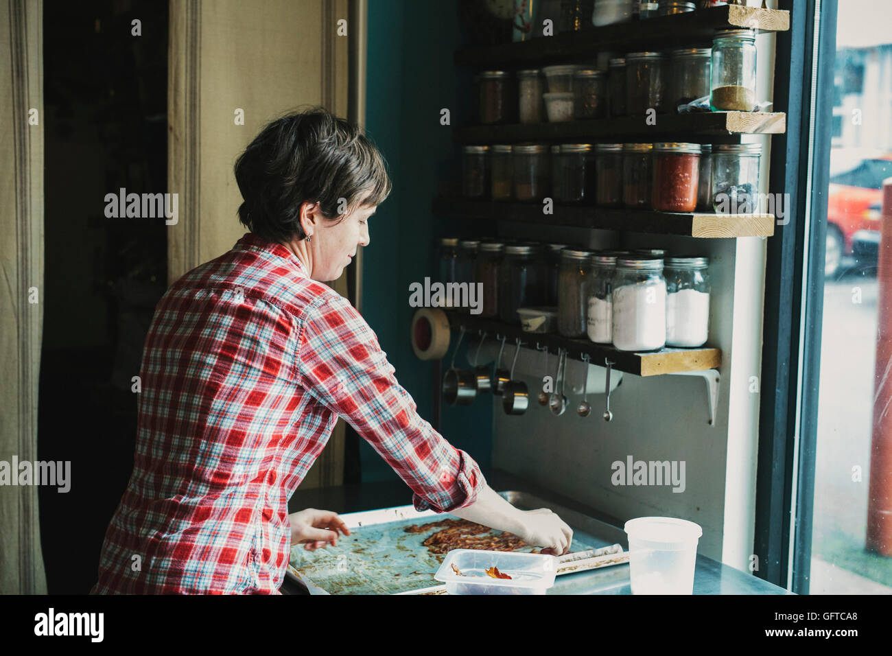 A woman with a tray of cooked bacon in a coffee shop kitchen Stock ...