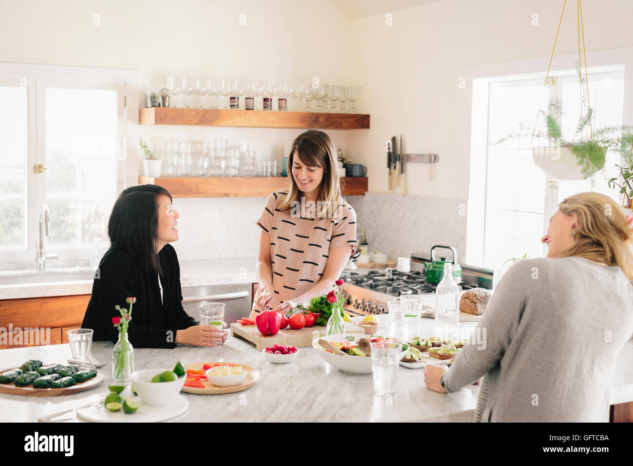 Three women talking and preparing lunch together Stock Photo - Alamy