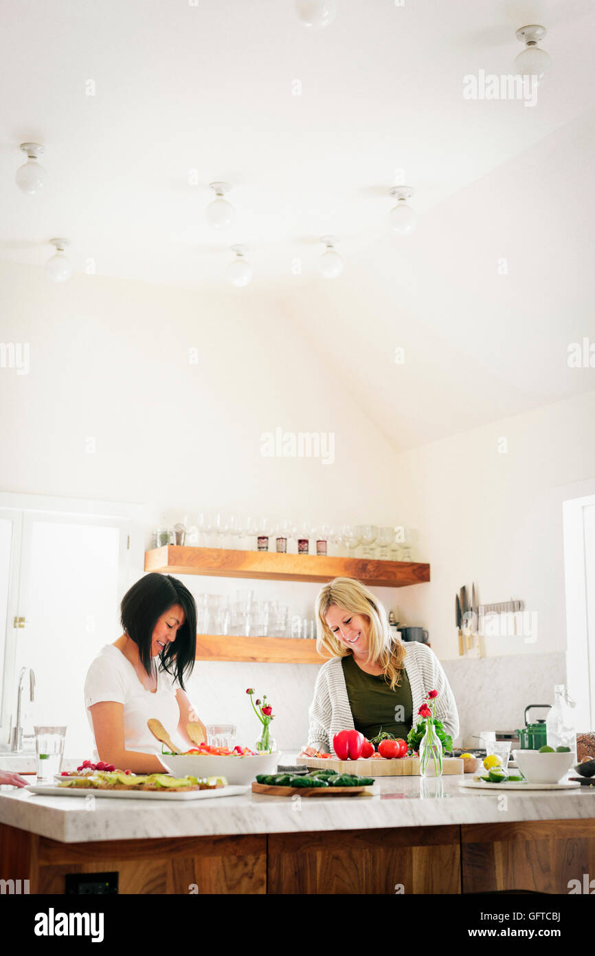 Two women preparing lunch in a kitchen Stock Photo - Alamy