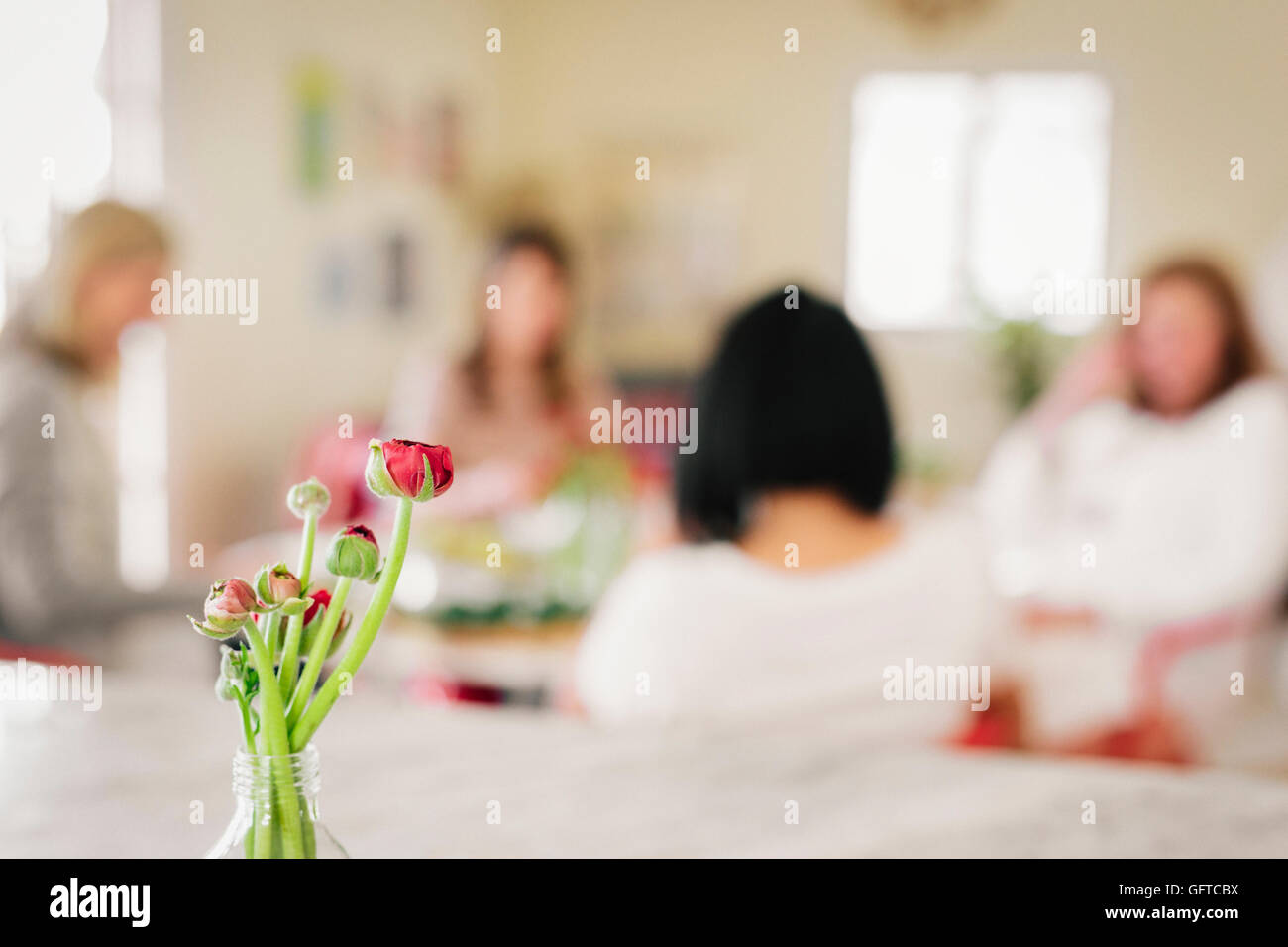 A group of women together around a table Stock Photo - Alamy