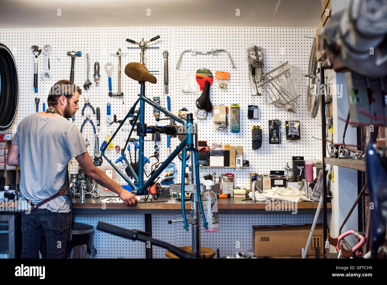 A man working in a bicycle repair shop Stock Photo - Alamy