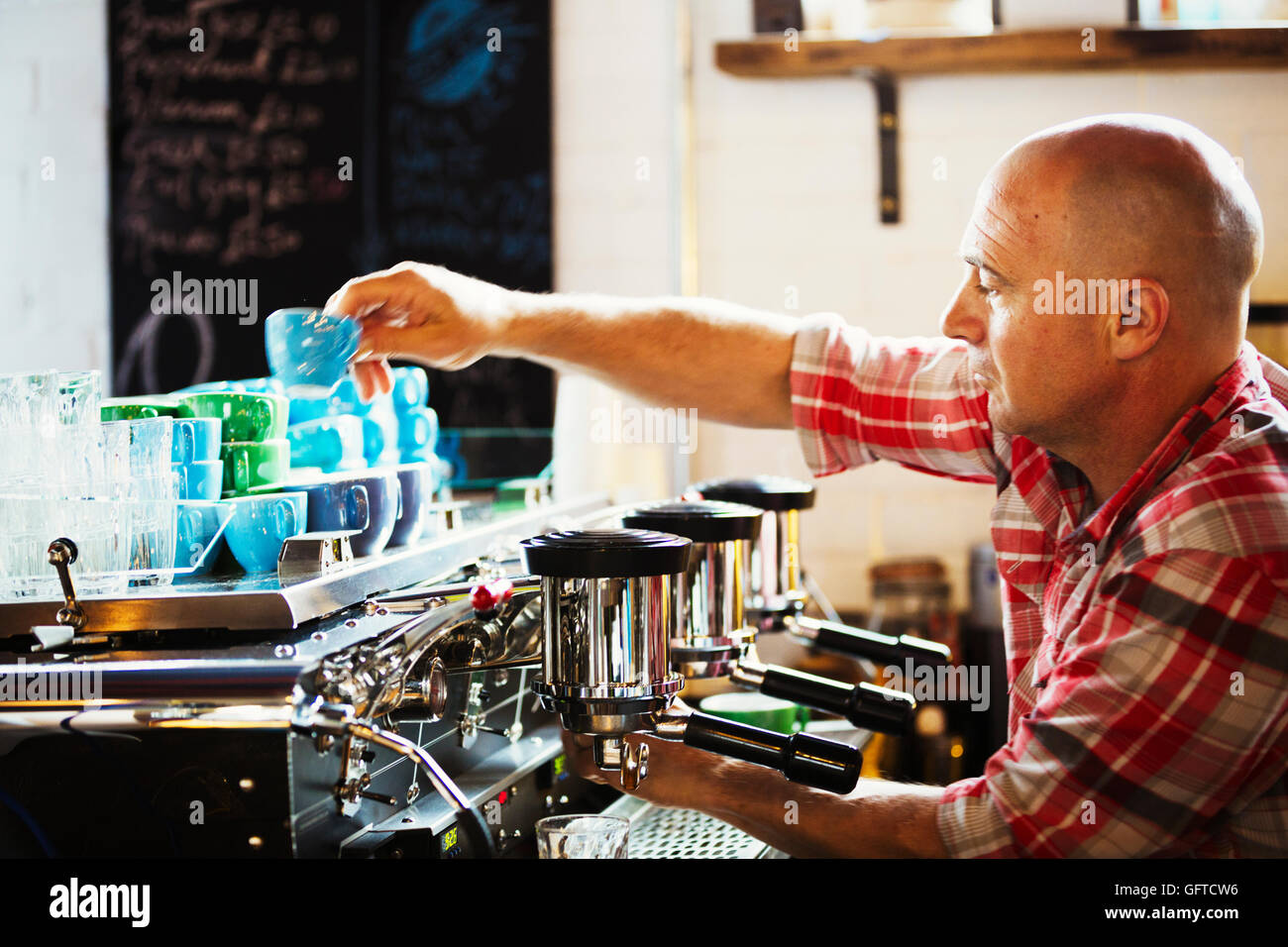 A man working a coffee machine making coffee Stock Photo - Alamy