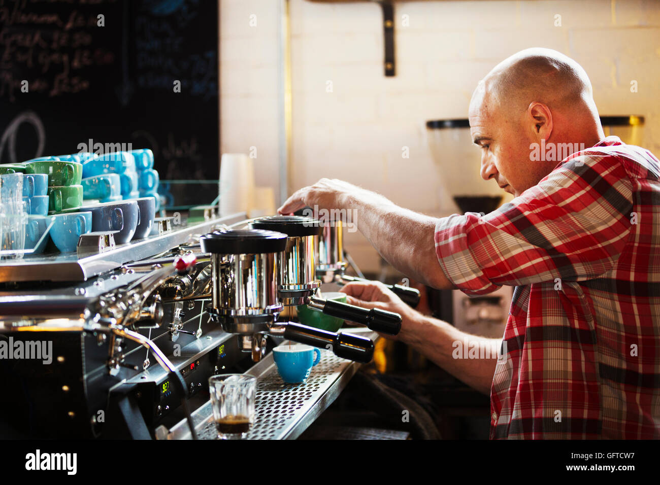 A man working a coffee machine making coffee Stock Photo - Alamy
