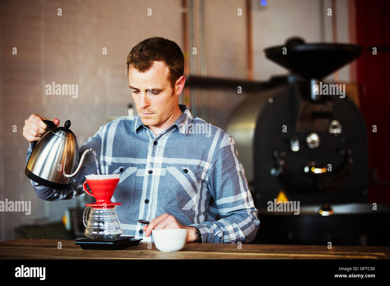 A man brewing coffee using a filter paper and drinking it Stock Photo ...