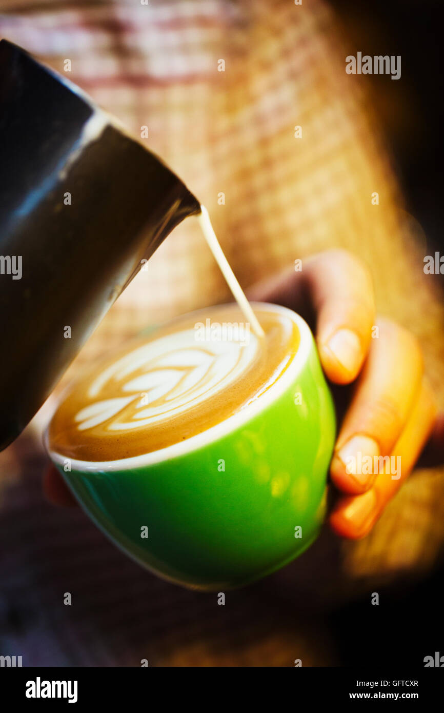 A barista creating a pattern in the froth on a cup of coffee Stock ...