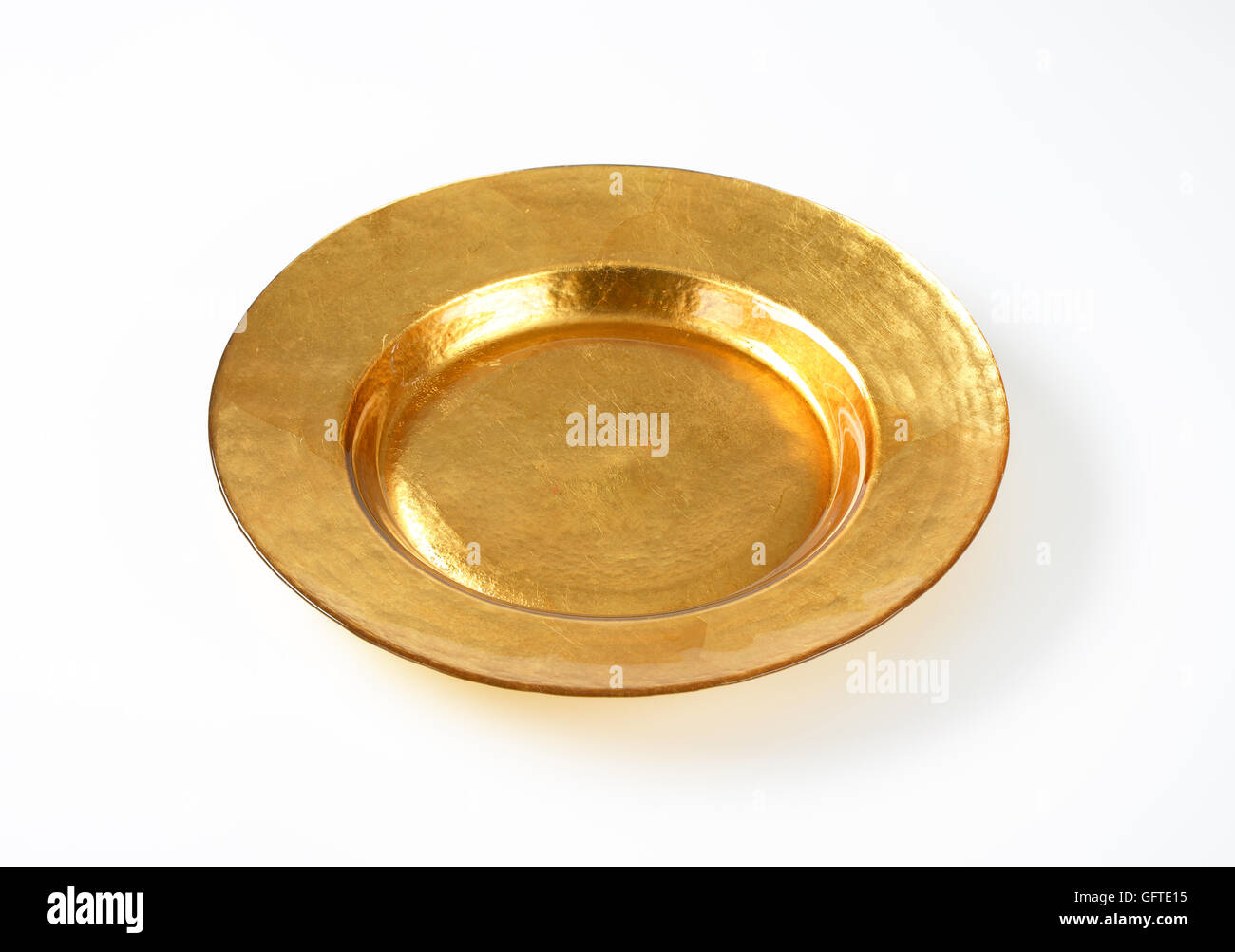 Empty gold plate with wide rim Stock Photo - Alamy