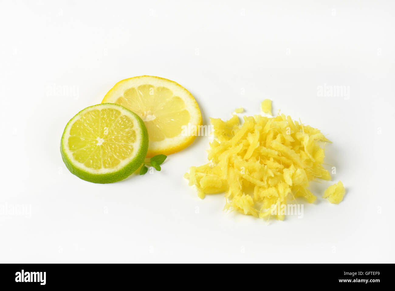 handful of grated fresh ginger and slices of lime and lemon on white ...