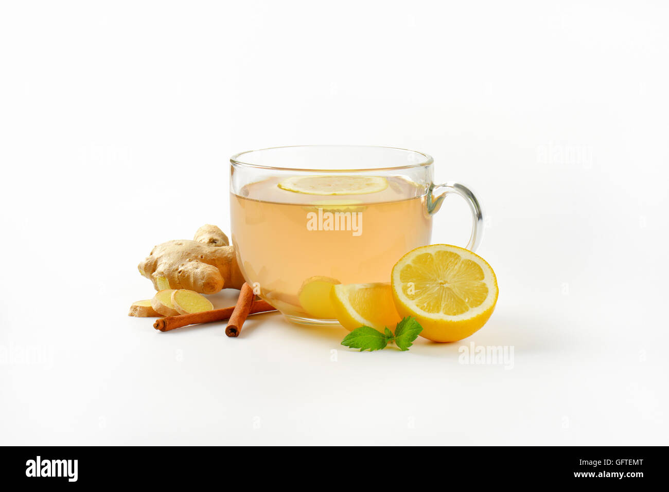cup of ginger tea with lemon, fresh ginger and cinnamon on white ...